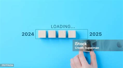 2024년부터 2025년까지 진행률 표시줄을 나무 블록으로 로드합니다 손이 나무 블록을 일렬로 놓아 2024년에서 2025년으로 전환되는 진행률 표시줄을 만들어 새해와