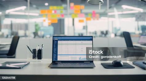 현대 크리에이티브 오피스의 책상 위에 서 있는 금융 분석 스프레드시트 응용 프로그램노트북 컴퓨터 다채로운 계획 노트와 배경 유리