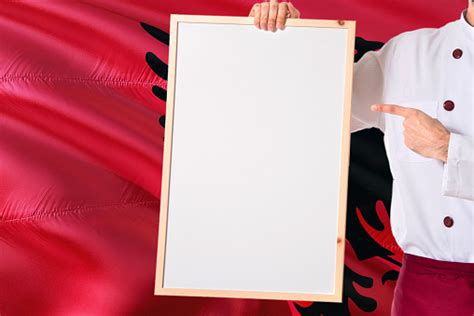 알바니아 셰 프에 빈 화이트 보드 메뉴를 잡고 알바니아어 플래그 배경 텍스트에 대 한 균일 한 포인팅 공간을 착용 요리 고급 요리에 대한 스톡 사진 및 기타 이미지 Istock