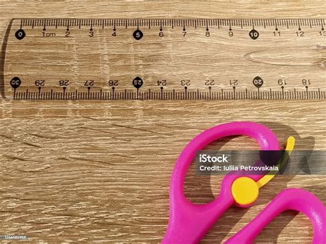 나무 테이블에 투명 플라스틱 학교 통치자 밀리미터와 센티미터는 검은색으로 표시됩니다 눈금자와 길이와 폭의 측정 밝은 분홍색 가위 플랫 레이 0명에 대한 스톡 사진 및 기타