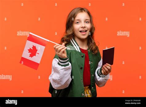 Girl Wearing In School Outfit And Holds Small National Flag Of Canada