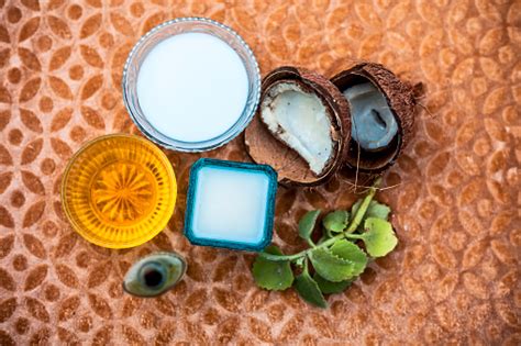 코코넛 밀크로 구성 된 유리 그릇에 나무 표면에 헤어 테라피 또는 모발 성장 치료제 또한 꿀과 올리브 오일과 원료 성분이 잘 섞여 있습니다 개념에 대한 스톡 사진 및 기타