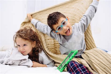 Premium Photo Siblings Playing On Bed