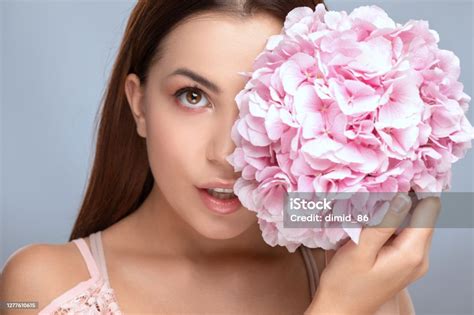 건강한 깨끗한 피부와 신선한 메이크업과 아름다운 갈색 머리 여자의 초상화 그녀는 얼굴 근처에 분홍색 수국을 안고 있다 미용 미용 및 메이크업 컨셉 16 17 살에 대한 스톡