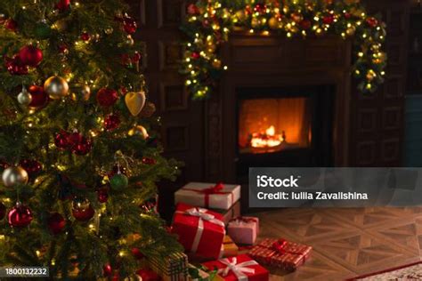 벽난로가 있는 고전적인 크리스마스 장식 인테리어 거실 도서관 붉은 황금 장식 장식이 있는 크리스마스 트리입니다 현대적인 고전적인 스타일의 인테리어 디자인 아파트 집에서