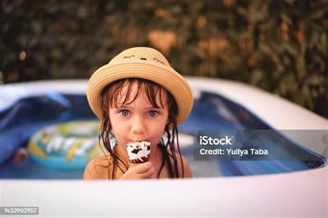밀짚 모자를 쓴 세 살짜리 아이가 풍선 수영장에서 수영을 하며 아이스크림을 먹는다 아이스크림에 대한 스톡 사진 및 기타 이미지 아이스크림 2 3 살 가정 생활