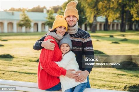 아름 다운 웃는 여자 잘생긴 남자와 함께 고 대 Bilduing 공원 마모에 대 한 그들의 작은 귀여운 딸 스탠드의 야외 초상화 경고 니트 의류 재미 있는 여행 3 명에