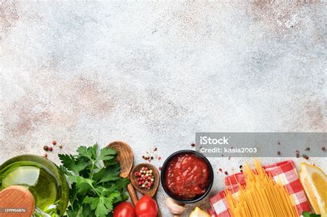 파스타 배경 파스타 스파게티 토마토 케첩 소스 올리브 오일 향신료 파슬리 신선한 토마토가 밝은 회색 슬레이트 테이블에 놓입니다 음식 요리 배경 복사 공간이 있는 상단