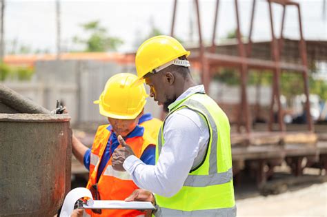 프리캐스트 콘크리트 공장 현장에서 프로젝트를 점검하는 감독과 작업자 건설 현장에서 논의하는 안전모를 쓴 엔지니어 및 건축업자 팀 2명에 대한 스톡 사진 및 기타 이미지