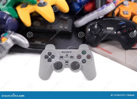 A PS Controller In Front Of Some Retro Video Game Controllers