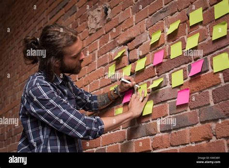 Male Executive Writing On Sticky Note Stock Photo Alamy