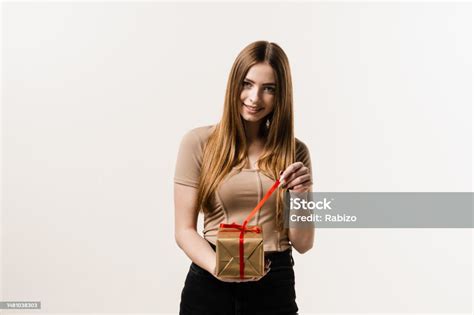 쾌활한 소녀는 흰색 바탕에 선물이 있는 선물 상자를 엽니다 이벤트 축하 행복한 젊은 여자가 웃고 생일이나 다른 휴일에 받은 선물과 선물을 들고 있다 20 24세에 대한 스톡