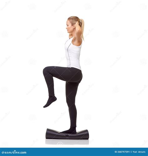 Balancing On Her Exercise Mat A Pretty Young Woman Working Out With Her Rolled Up Exercise Mat