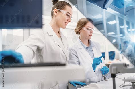 A Team Of Laboratory Technicians Conduct A Series Of Tests On A Chemical Analyzer In A