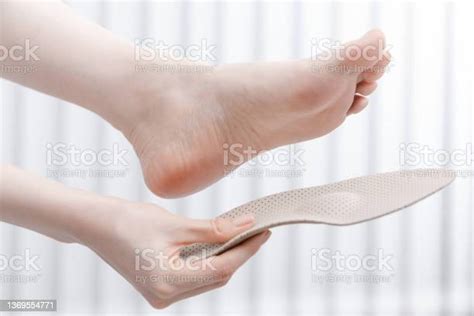 실내에서 정형 외과 깔창을 피팅 여성 가까이 집에서 발 옆에 깔창을 들고 있는 소녀 정형 외과 깔창 풋 케어 배너 플랫 피트