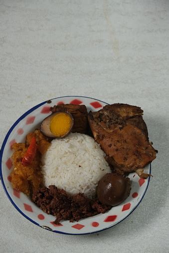 Nasi Gudeg Krecek은 가공된 어린 잭프루트 코코넛 밀크 향신료 두부 계란 및 닭고기로 만든 쌀과 구데그입니다 족자카르타 특산품 인도네시아 음식 오래된 접시와