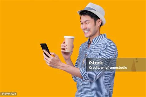 여행 준비 스마트폰과 커피 컵을 사용하여 아시아인 웃는 쾌활한 남성 남자 손 비행 일정 확인 수하물 가방 새로운 해외 여행 준비 노란색 배경에 촬영 한 여행 스튜디오 여름에