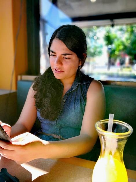 Premium Photo Woman Using Mobile Phone At Table In Restaurant