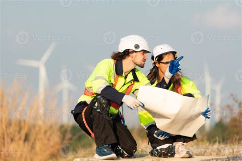 Man And Female Engineer Stationed At The Natural Energy Wind Turbine Site With Daily Audit
