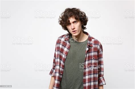 캐주얼 서 서와 스튜디오에서 흰색 벽 배경에 고립 된 찾고 카메라에 불쾌 한 자극 된 젊은 남자의 초상화 사람들은 진심으로 감정