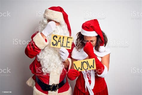 산타 의상을 입은 커플은 코와 눈을 문질러 피곤 한 흰색 배경에 와우와 판매 배너를 들고 피로와 두통을 느끼고 스트레스와 좌절 개념 2명에 대한 스톡 사진 및 기타 이미지