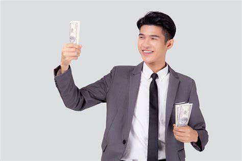 백인 배경에 고립 된 돈 달러를 들고 젊은 아시아 사업가 은행권과 성공을 들고 정장 사업가와 금융 저축 및 투자 소득 및 지출에