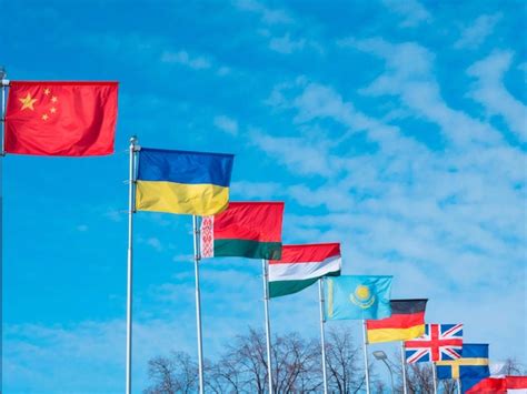 На флагштоках развеваются несколько национальных флагов разных стран ...