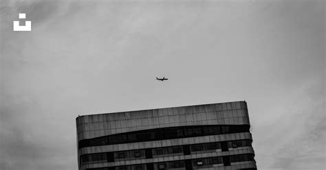 건물 위를 날아다니는 비행기 사진 Unsplash의 무료 회색 이미지