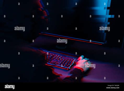 Hacker In The Hood Working With Computer Typing Text In Dark Room