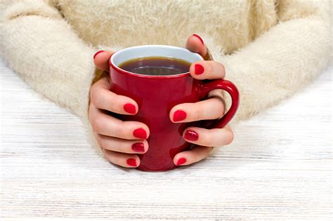 여성의 손은 아름다운 빨간 겨울 매니큐어와 흰색 푹신한 스웨터의 배경에 빨간색 컵을 잡고 마시고 패션 아침 새해 축하 차 커피 건강한 생활방식에 대한 스톡 사진 및 기타