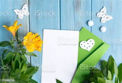 빈 종이를 모의 흰색 색상과 나비의 자연 꽃 어두운 나무 배경에 메일 봉투 빈 텍스트 프레임입니다 꽃과 인사말 카드 디자인입니다 나무 바탕에 올레순 위에서 보기 0명에 대한