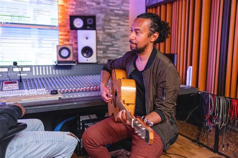 음악 믹서 옆의 녹음 스튜디오에서 어쿠스틱 기타를 연주하는 흑인 남성 기타리스트 기타 연주자에 대한 스톡 사진 및 기타 이미지