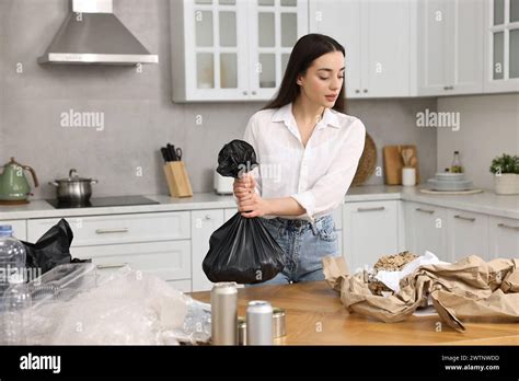 Garbage Sorting Woman With Plastic Bag At Table In Kitchen Stock Photo Alamy
