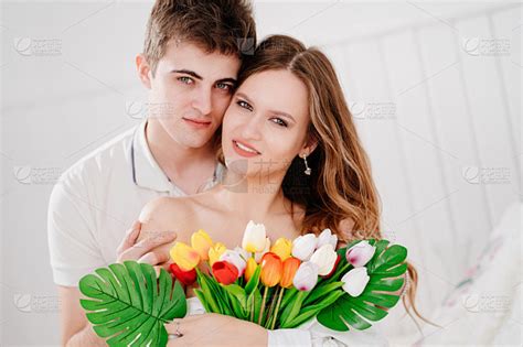 一个男人送给他心爱的女人一束彩色的郁金香。温柔的拥抱。