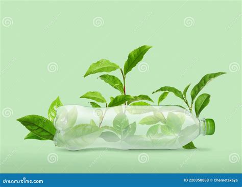 Bottle Made Of Biodegradable Plastic And Leaves On Green Background