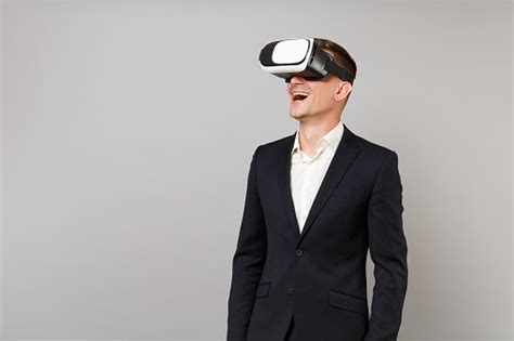 고전 검은 양복 스튜디오에서 회색 벽 배경에 고립 된 헤드셋을 찾고 셔츠에 젊은 비즈니스 남자를 웃 고의 초상화 업적 경력 자산