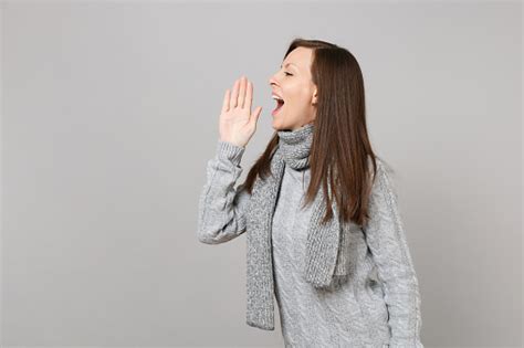 회색 스웨터 옆에 보이는 스카프 회색 배경에 고립 된 손 제스처와 비명에 젊은 여자 건강 한 패션 라이프 스타일 사람들은 진지한