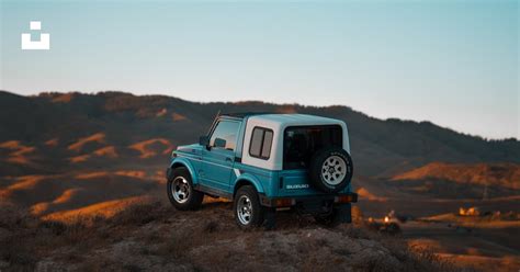 낮 동안 하얀 하늘 아래 갈색 들판에 파란색 Suv 사진 Unsplash의 무료 보이즈 이미지