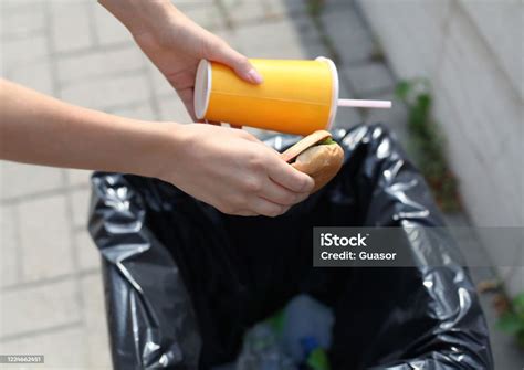 패스트 푸드와 건강에 해로운 먹는 개념 도시 거리에 쓰레기통에 플라스틱 컵으로 햄버거를 던지는 손 쓰레기 수거통에 대한 스톡 사진 및 기타 이미지 Istock