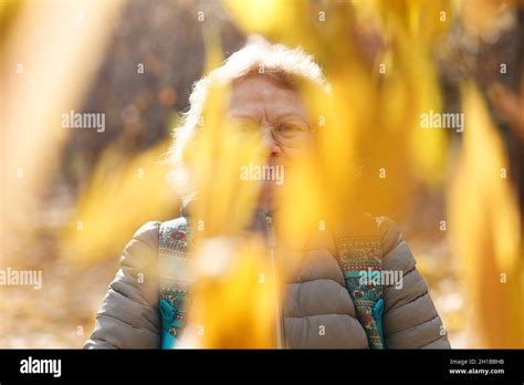 Adult Mature Fall Woman Throw Up Autumn Leaves Outside In Colorful Fall