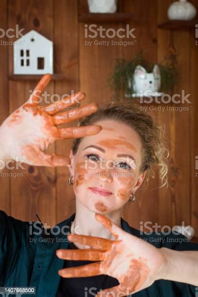 선택적 초점 창조적 인 직업 세라미스트 쾌활한 예술가 전문 도공 아름다운 곱슬 중년 여성의 초상화 갈색 점토에 얼굴을 가진 마스터 도자기 스튜디오의 소유자 갈색에 대한 스톡