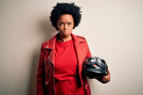 오토바이 헬멧을 들고 곱슬 머리를 가진 젊은 아프리카 계 미국인 Afro 오토바이 여자우울하고 고민에 대한 걱정 분노와 두려워