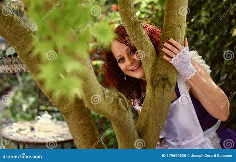 Alice In Wonderland Looking Through A Tree Royalty Free Stock Image