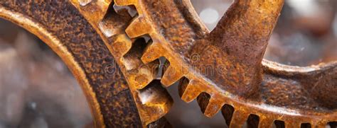 Detailed View Of Two Interlocking Rusty Gears Highlighting Their Aged And Textured Surfaces