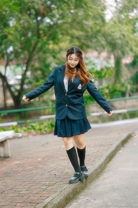 야외에서 교복을 입은 젊은 여성 · 무료 스톡 사진