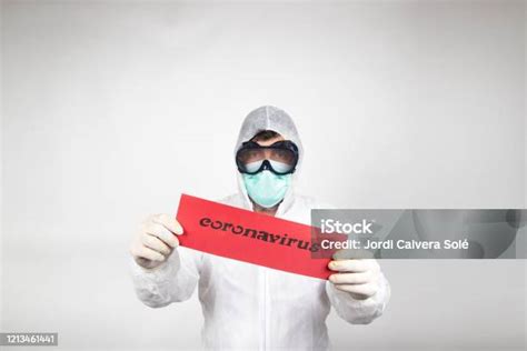 외과 용 마스크 안경 흰색 보호 복 및 흰색 배경에 스튜디오에서 고립 된 코로나 바이러스라는 단어가있는 빨간색 기호를 가진 남자