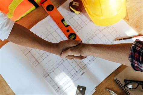 건설 현장 건물 팀워크 파트너십 산업 개념에서 프로젝트 계약을 시작 인사에 비즈니스 회의를 완료 한 후 평면도 건설 노동자 팀 계약자 손 흔들어 Diy에 대한 스톡 사진 및