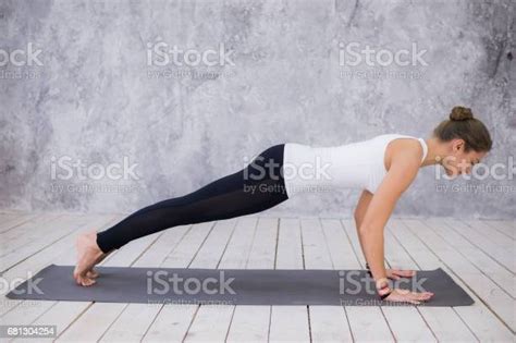 아름 다운 젊은 여자 실내 운동 흰 벽과 방에 요가 운동을 하 고 아래로 직면 개 포즈 Adho Mukha Svanasana 태양 인사말 포즈 전체 길이 측면 보기 20