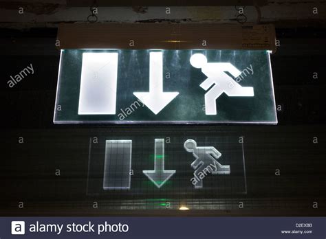 An Iluminated Exit Sign And It S Reflection In A Glass Door Stock Photo Alamy