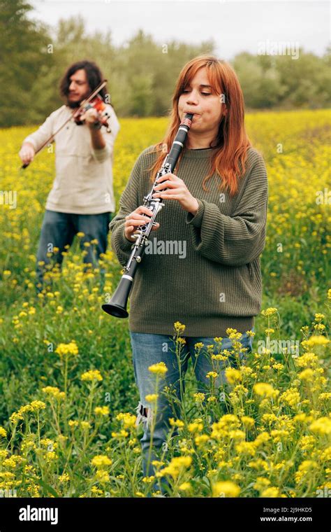 Man And Woman Practicing Musical Instruments In Flower Field Stock Photo Alamy